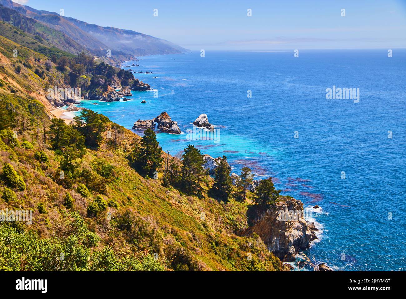 Vibrant blue ocean on west coast with mountains and rocks Stock Photo ...