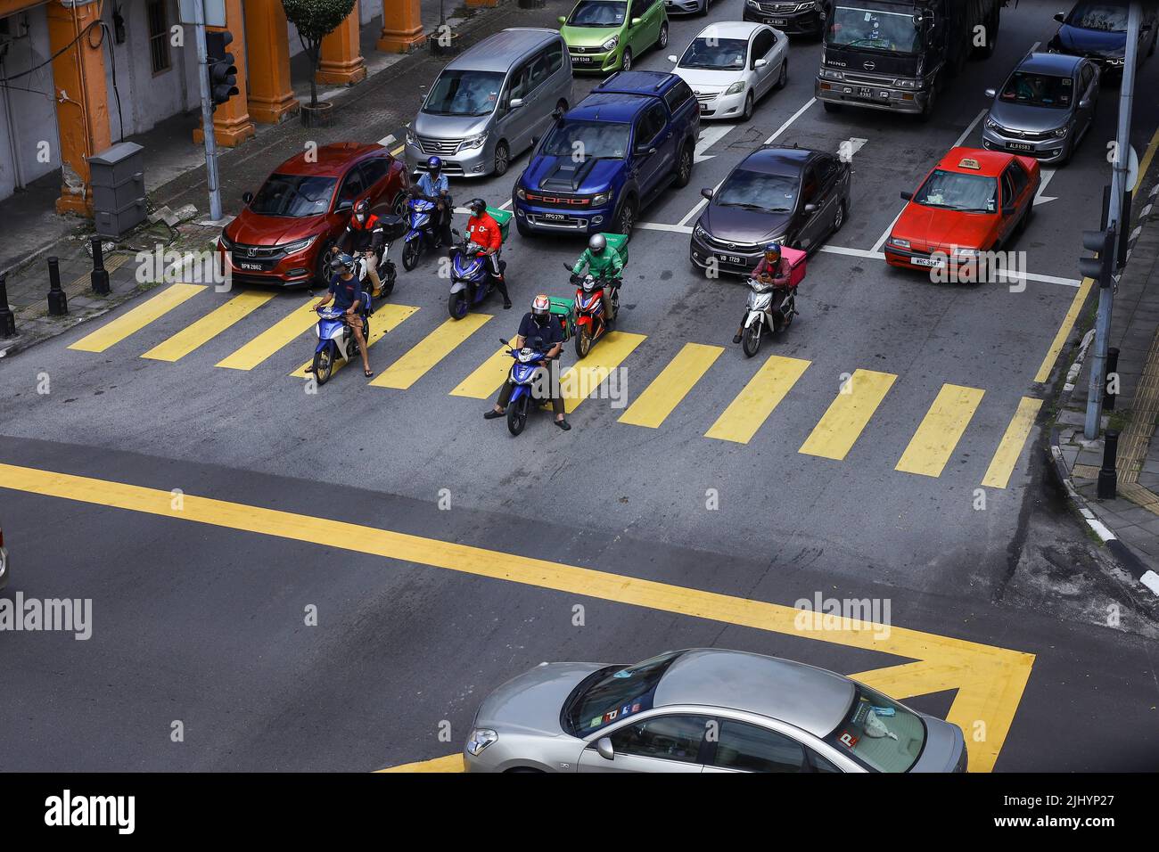An aerial view of delivery motorcycles and cars in the street in Kuala ...