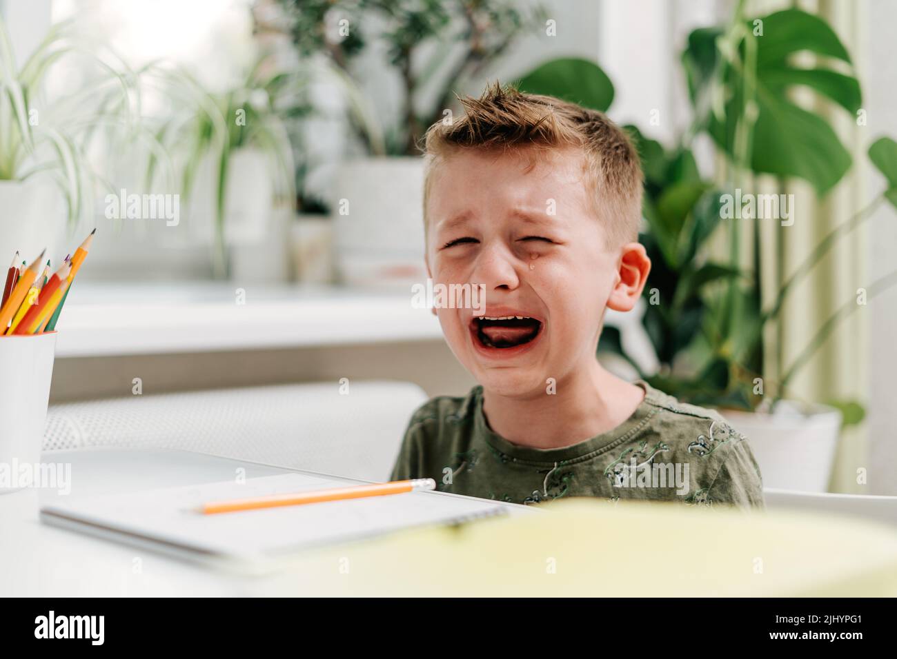 Back to school. Crying school kid boy studying at home and doing ...