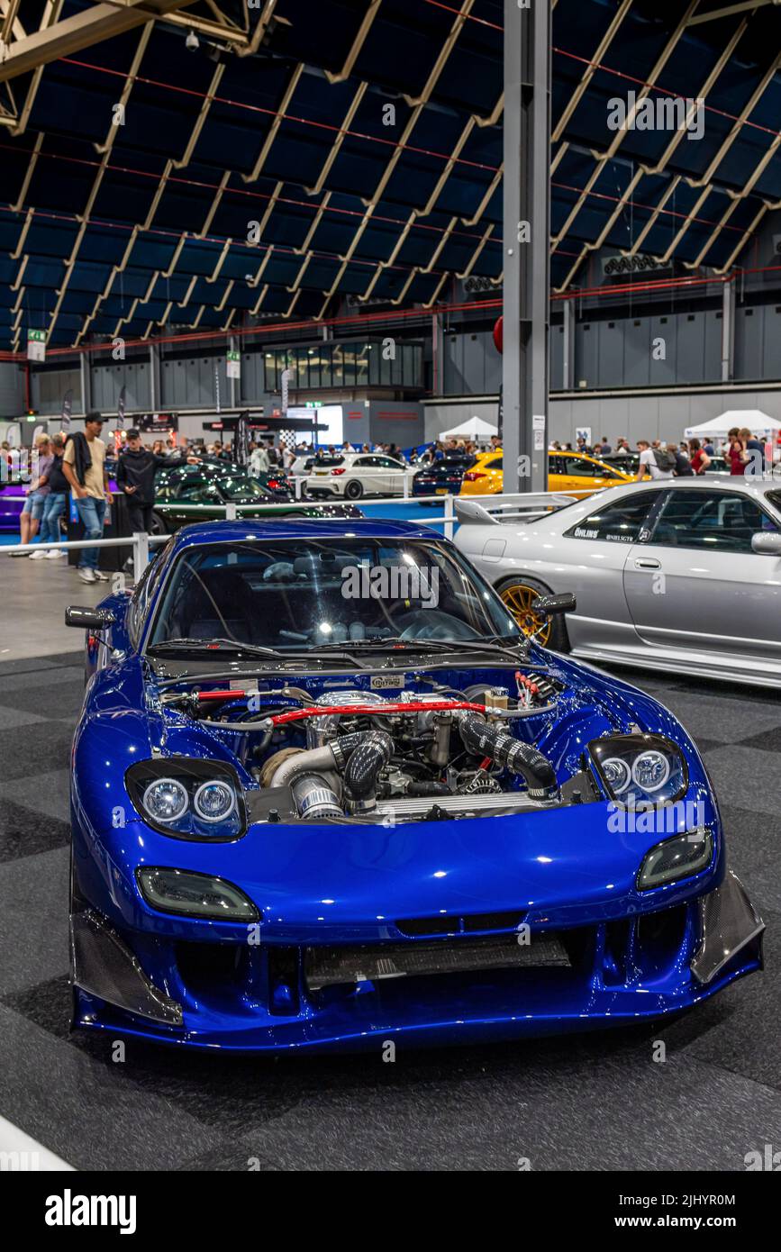 A vertical shot of a blue Mazda RX 7, a sportscar model at the World of Cars show, built in 1995 ...