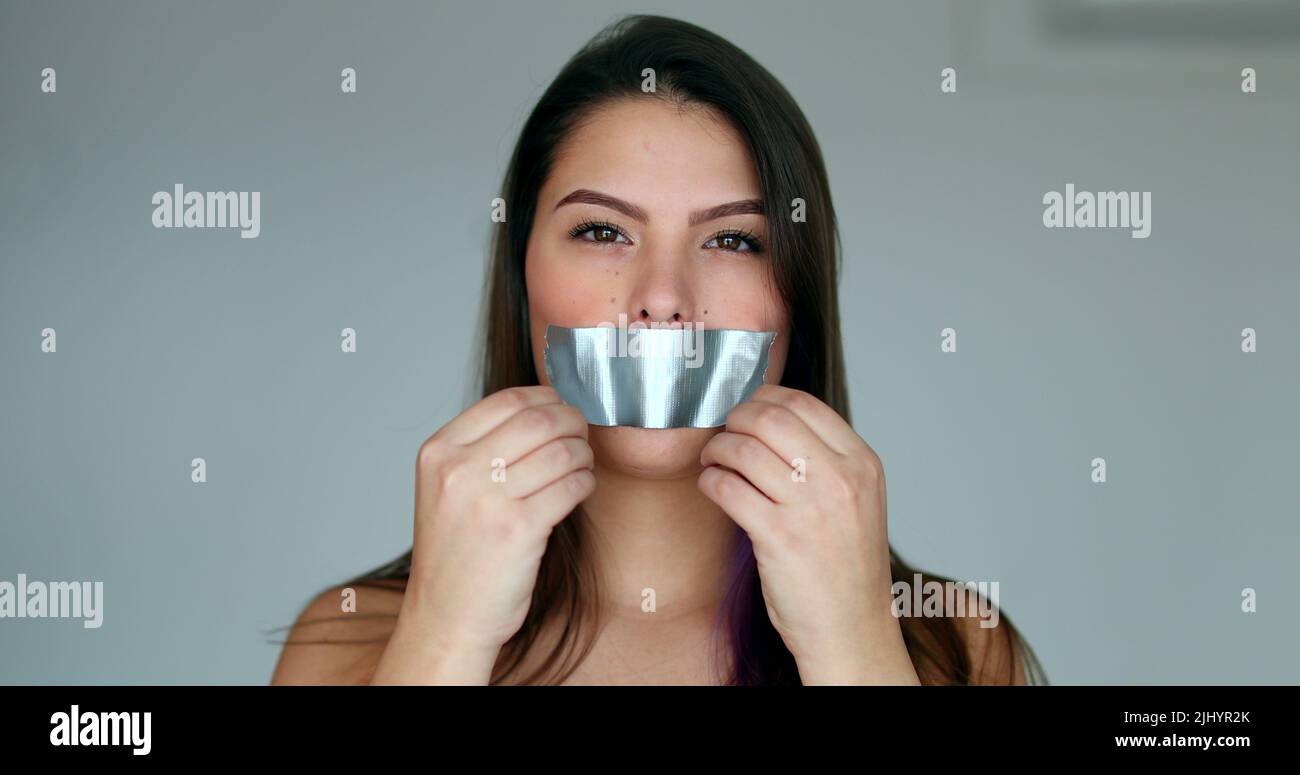 Assertive woman removing tape from mouth feeling relief and freedom to ...