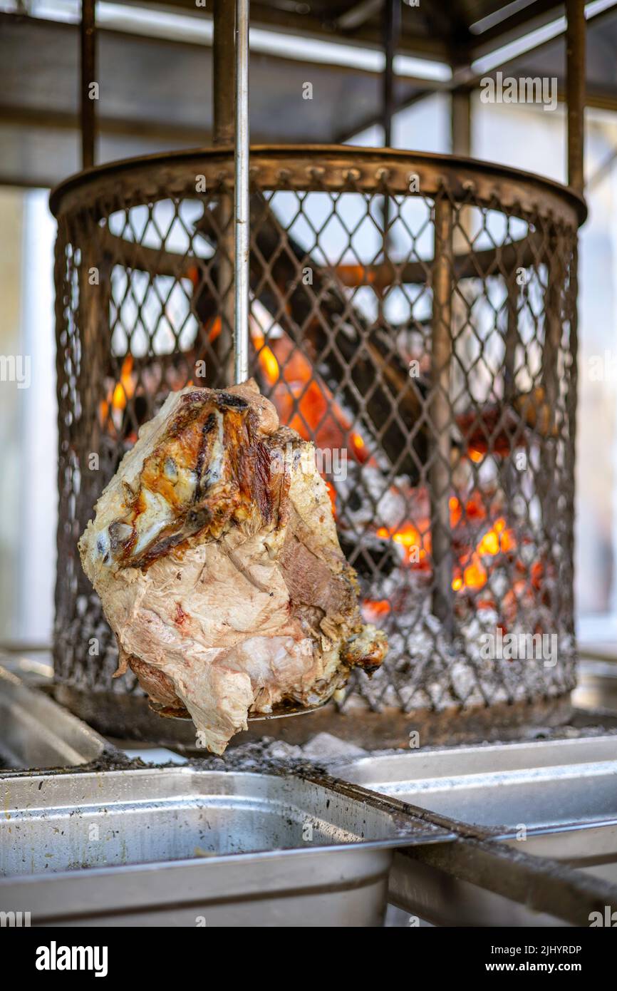 Pork ham barbecue grilled over a wood fire. Rotating vertical ...
