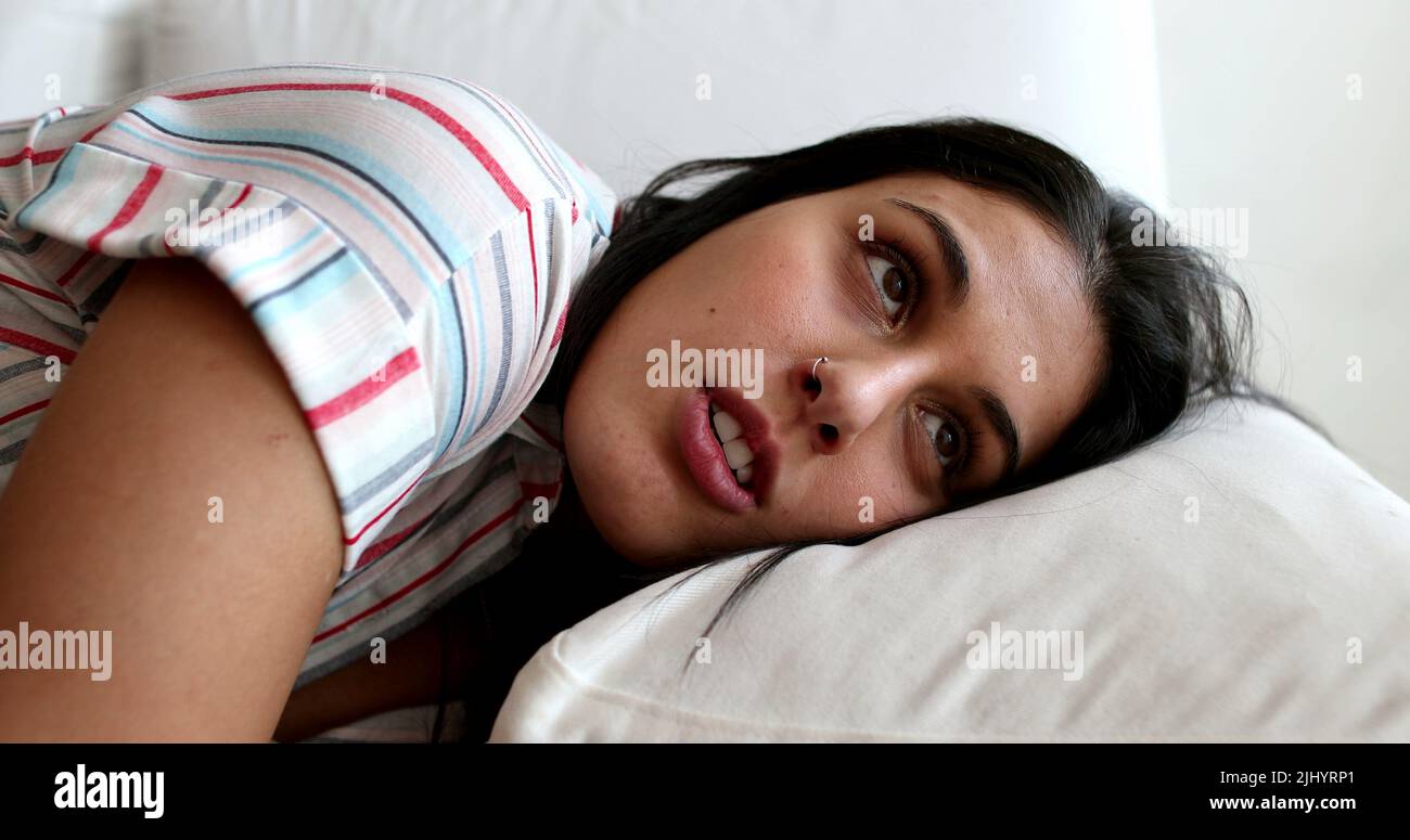 Depressed young woman feeling sad slouched in couch. Pensive girl feel ...