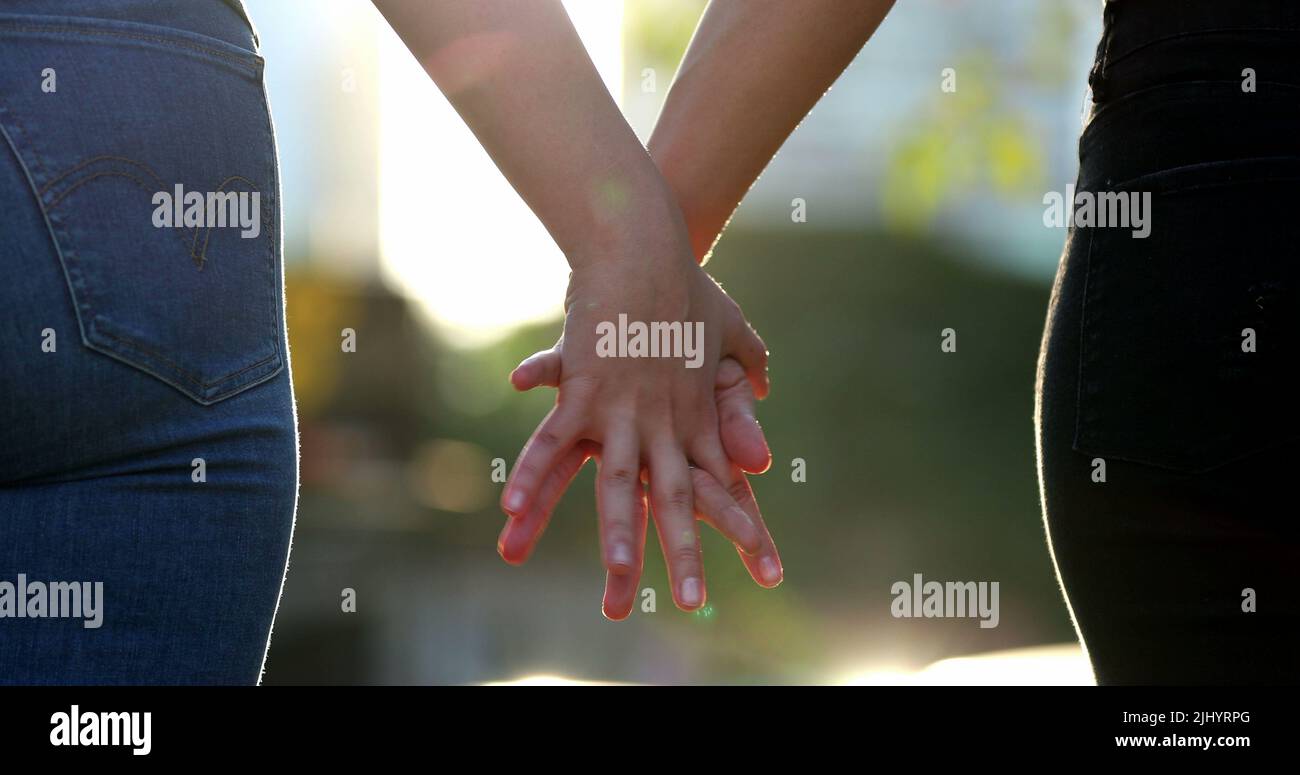 Close-up of hands joining together with sunlight flare in the ...