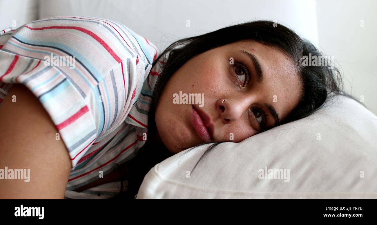 Depressed young woman feeling sad slouched in couch. Pensive girl feel ...