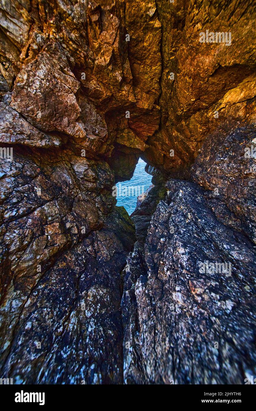 Tunnel of sharp rocks leading to ocean water Stock Photo - Alamy