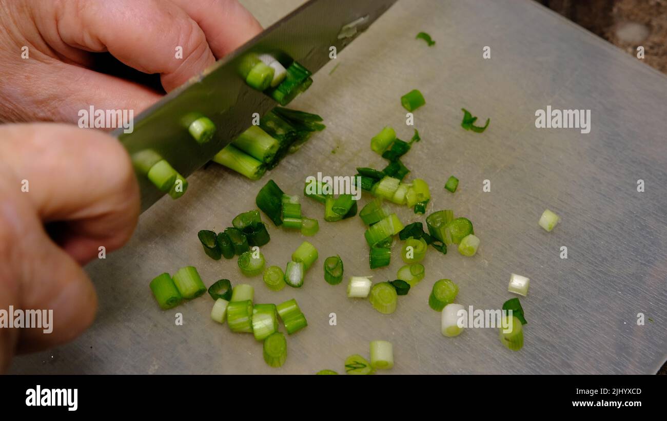 old woman hands cutting young onion on the kitchen Stock Photo - Alamy