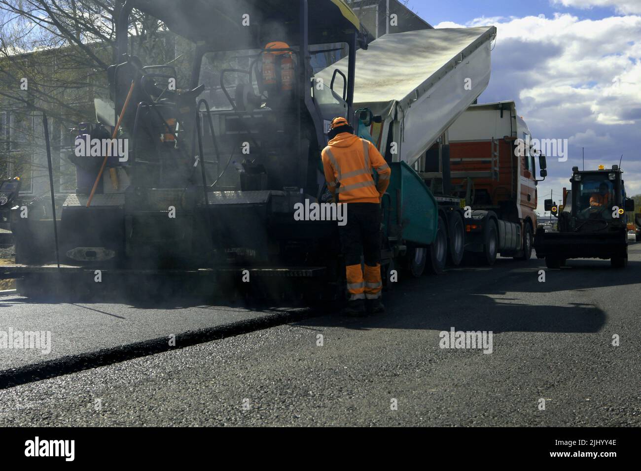 road paver worker. asphalt machine on road repair site. renewal process ...