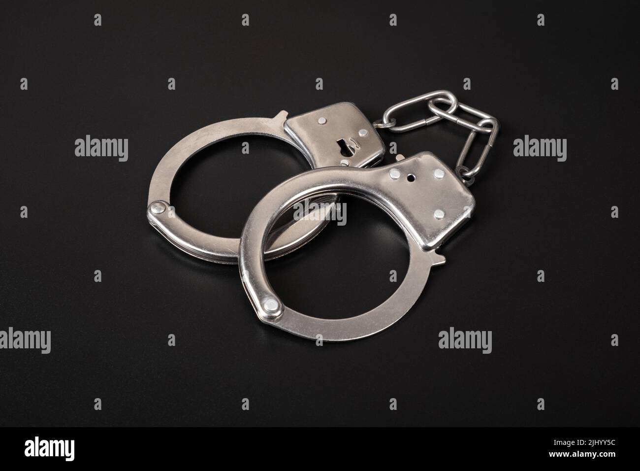 handcuffs on dark background, concept arrest Stock Photo - Alamy