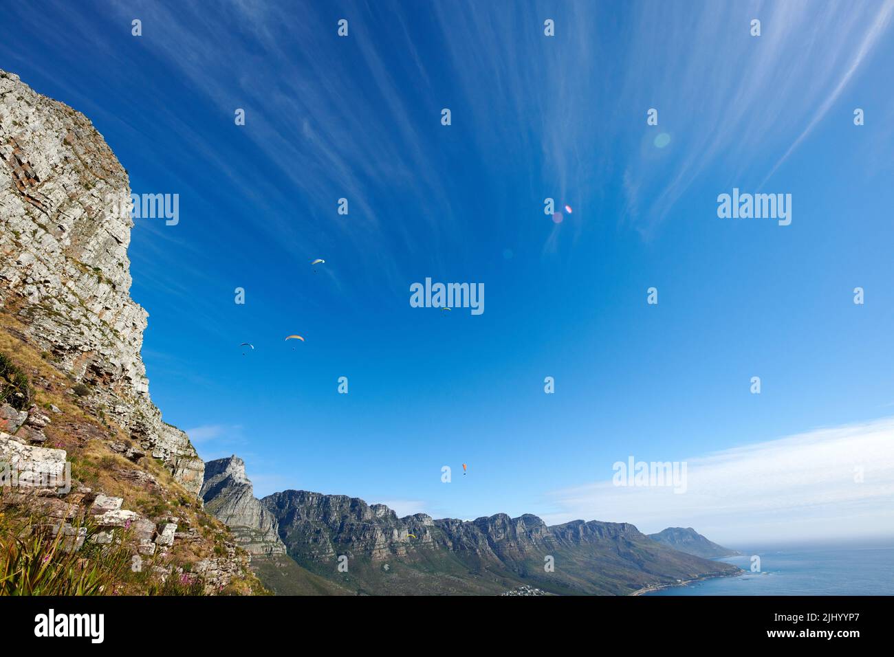 Paragliding across the sky, flying high above the ocean and mountain ...