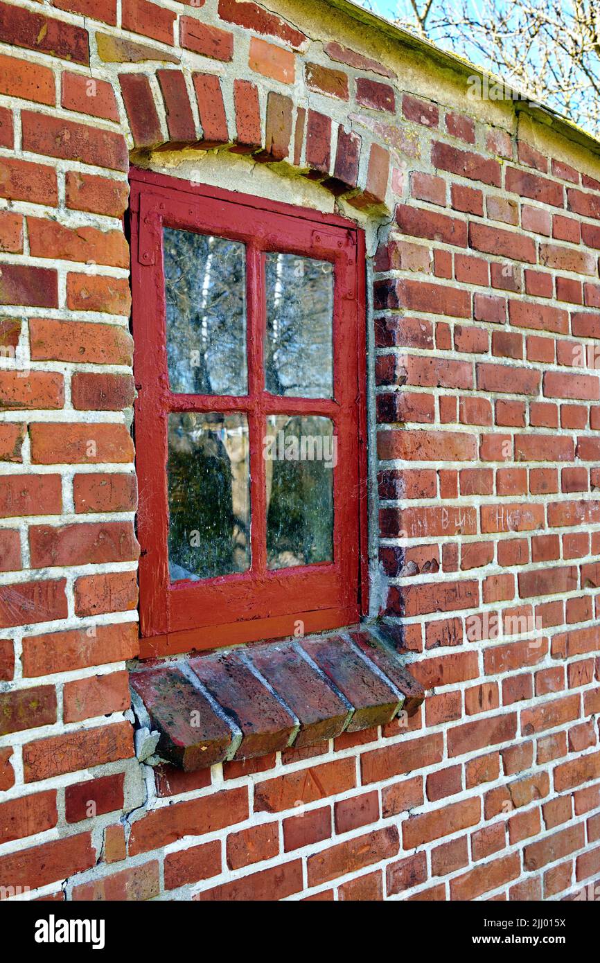 Old dirty window in a red brick home. Ancient casement with red wood ...