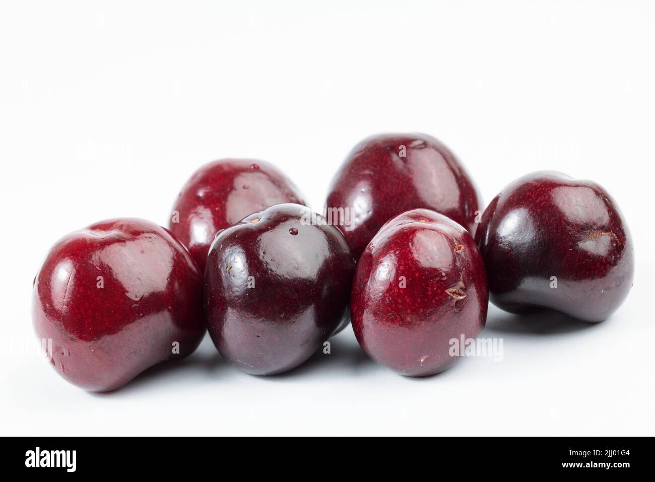 A few delicious cherries on white background Stock Photo - Alamy