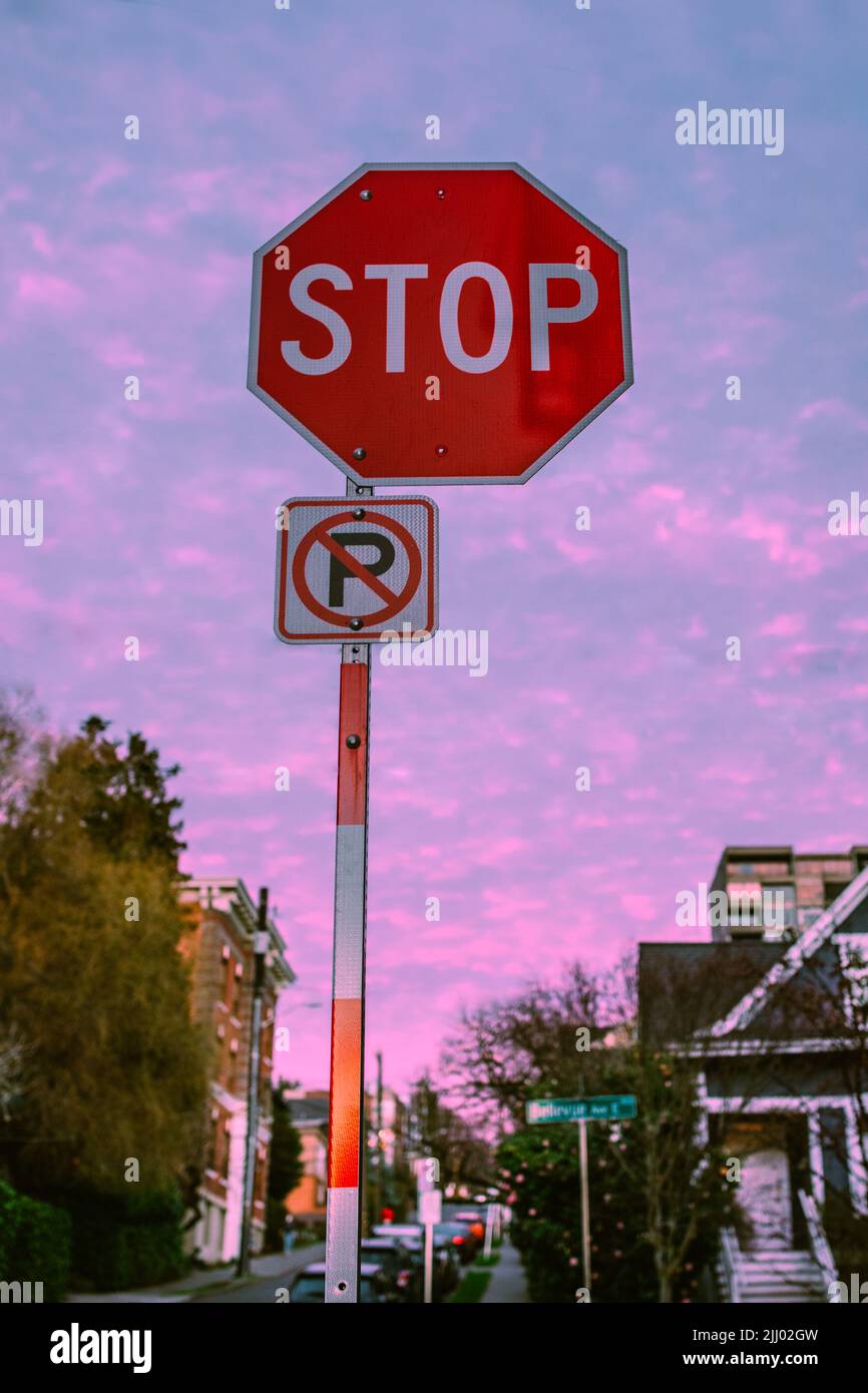 Stop sign, no parking sign at sunset with pink sky on Bellevue street ...