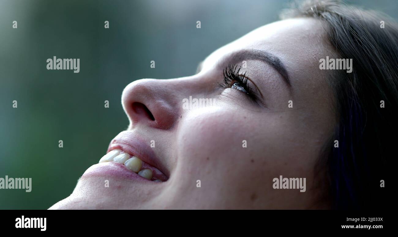 Happy woman looking up to sky with hope and faith smiling Stock Photo ...