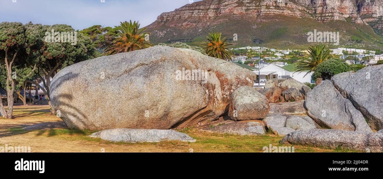 Landscape view of beach rocks and boulders with lush trees and grass ...