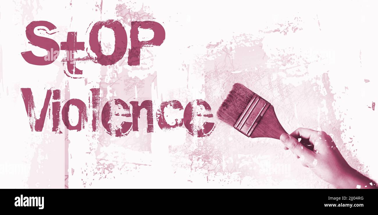 Stop Violence message on wall with paintbrush in hand. Domestic abuse ...