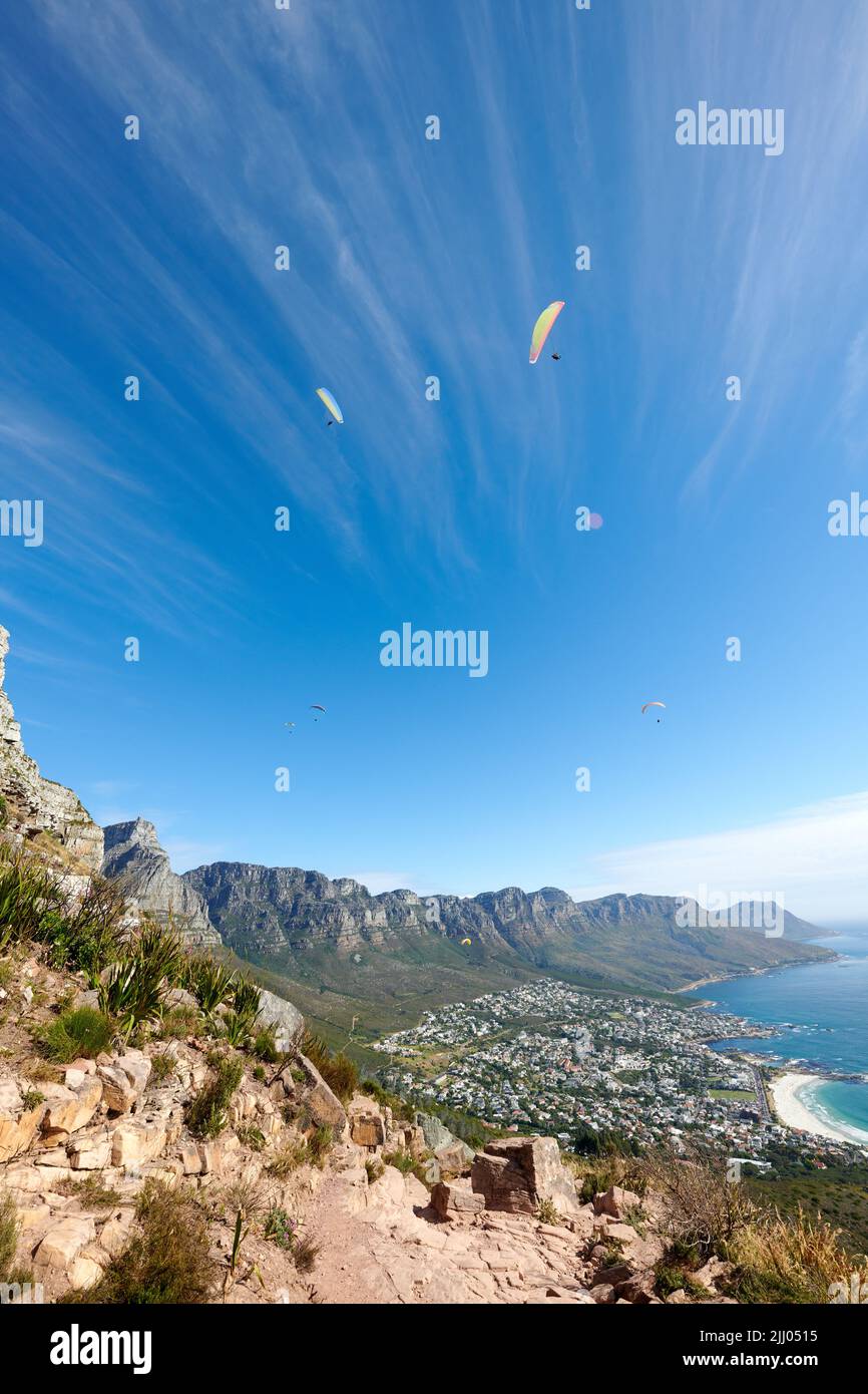 People paragliding from a mountain with a scenic view in summer ...