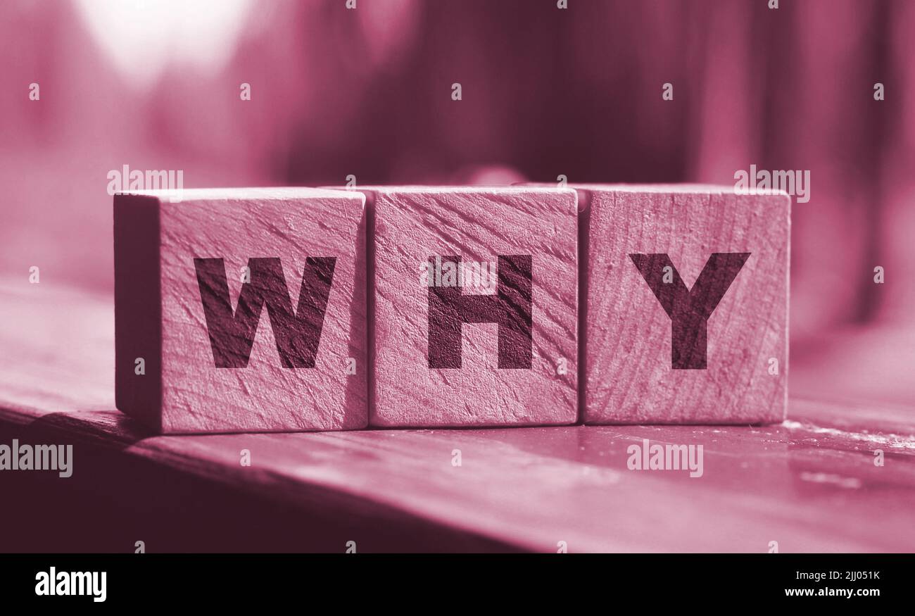 WHY cube blocks arranged on green nature background Stock Photo - Alamy