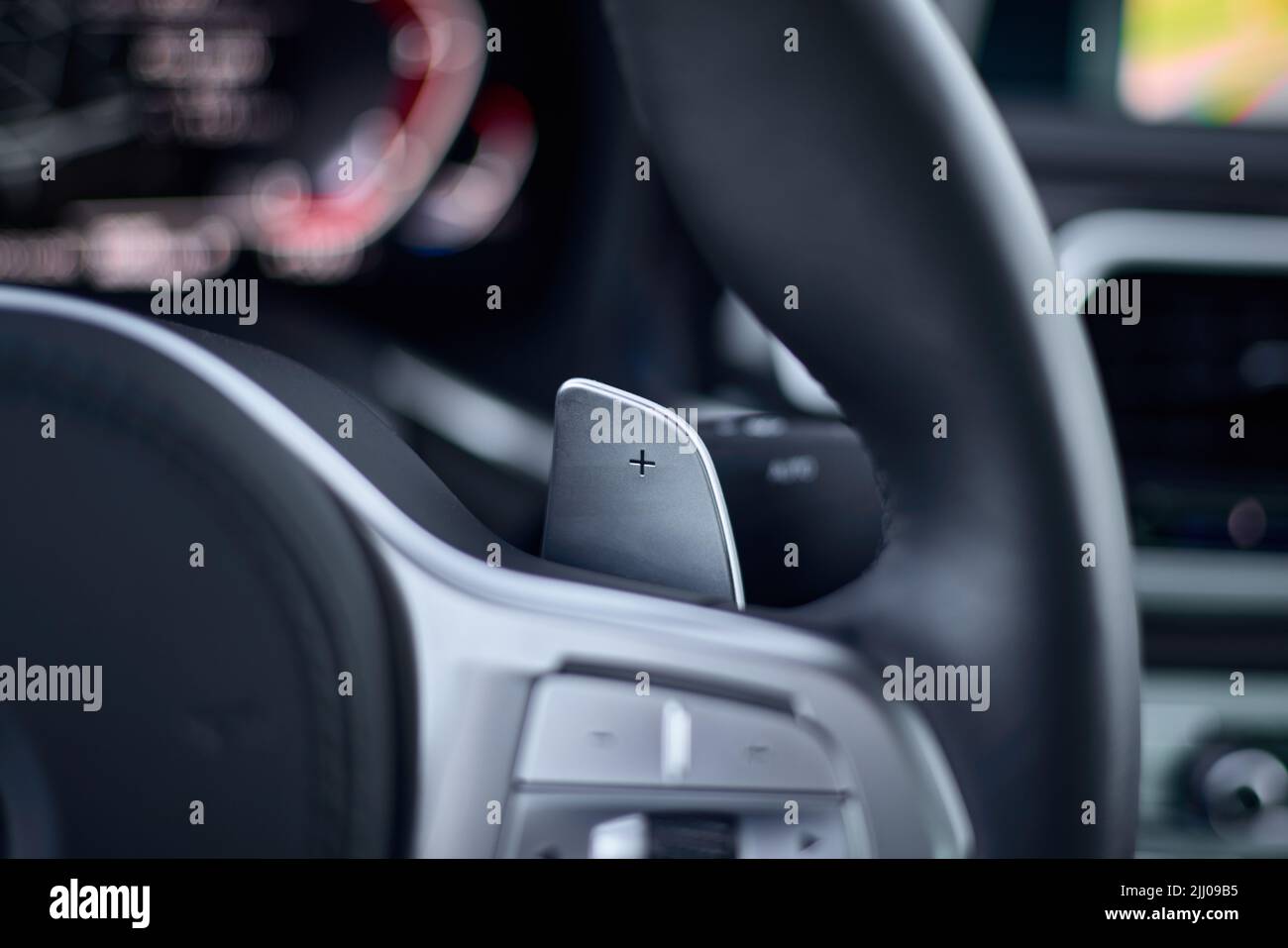The pad of the automatic gearbox on the steering wheel of a luxury car ...