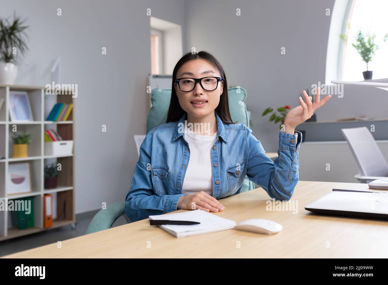 Distance Learning. A young Asian woman is a teacher, conducts online ...
