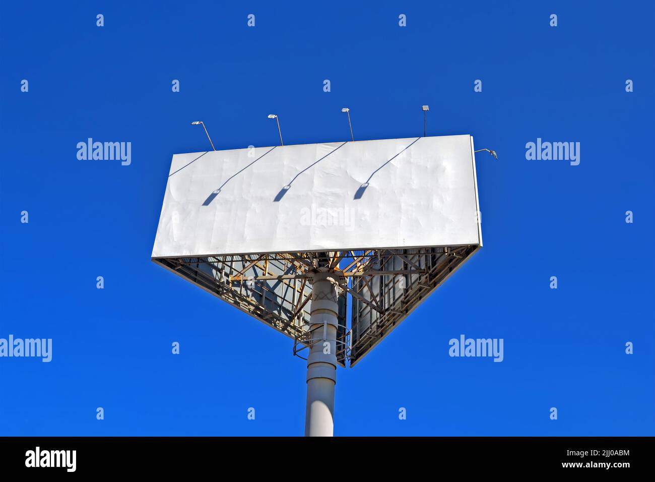 huge empty wide billboard aka big triangle board on pylon on blue sky ...