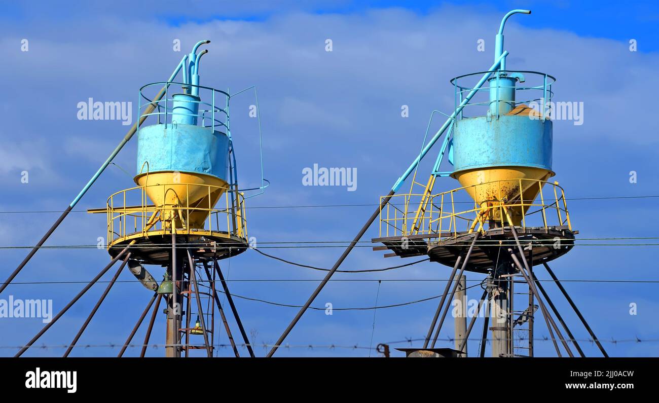 few large color grain bin bunker (dispenser and dryer) behind the wires ...