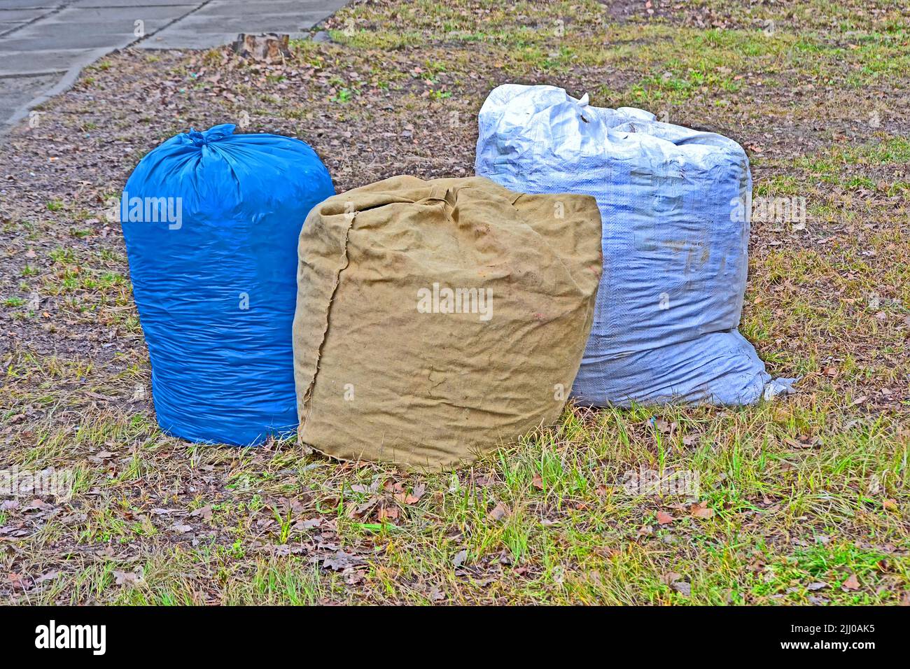 few color trash bags on the grass, polluted environment diversity Stock ...
