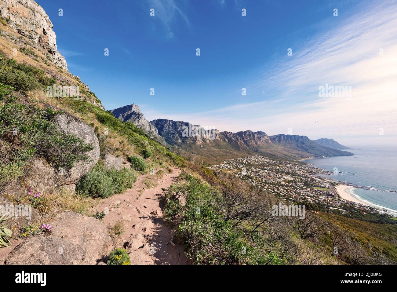 Scenic coast and rocky mountain slope with a cloudy blue sky background ...