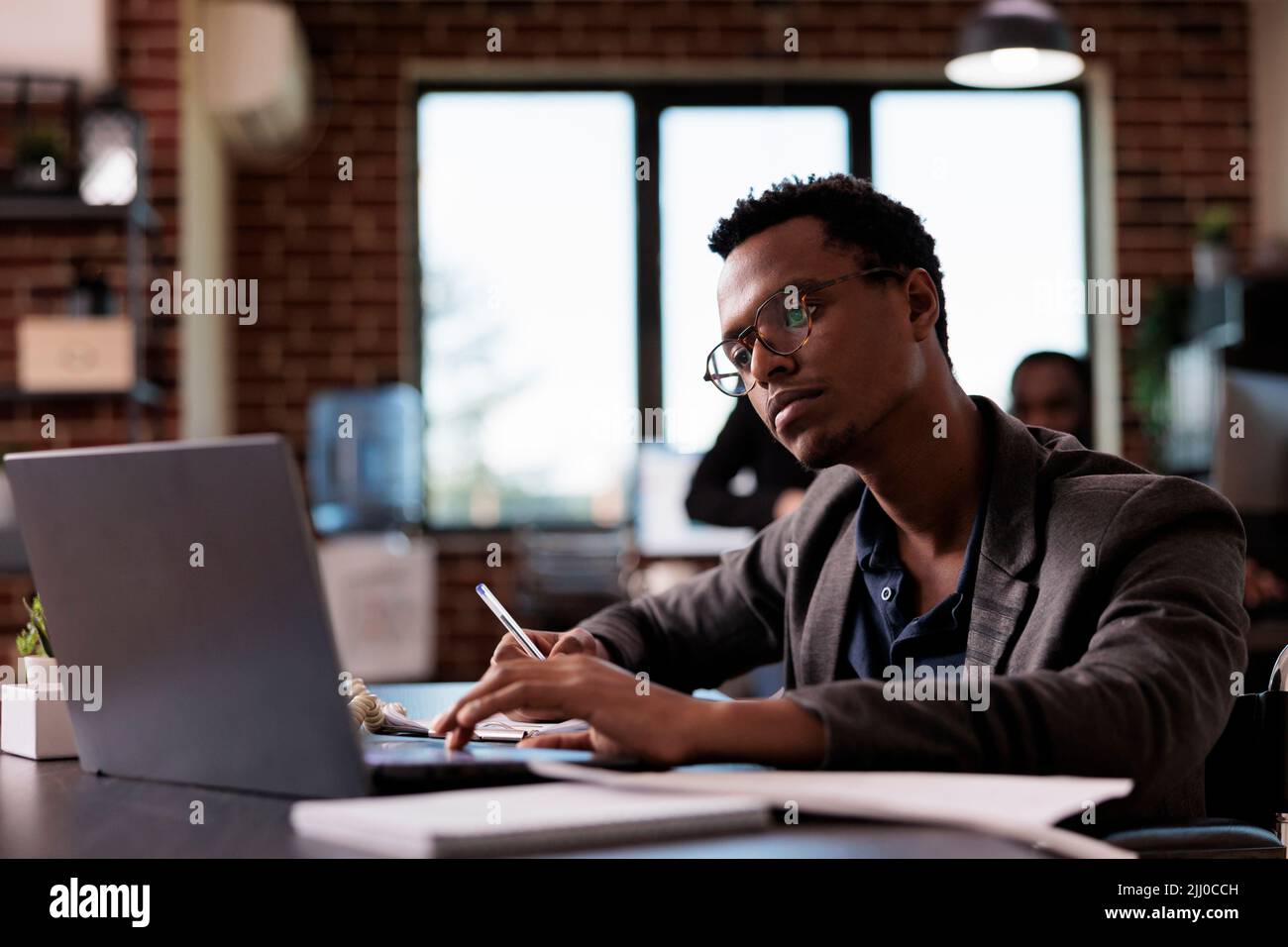 African american man with impairment analyzing online report on laptop ...