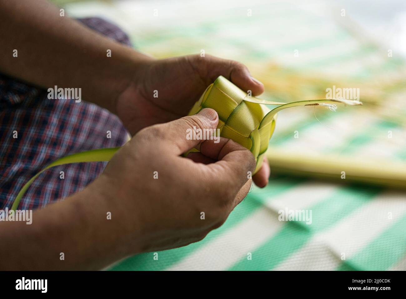 Weaving the coconut leaves making the ketupat, a traditional Malay ...