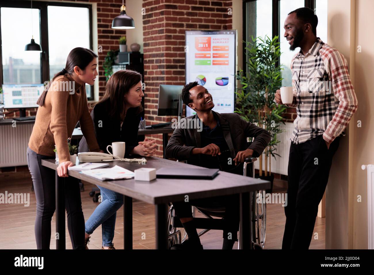 Business partners laughing together in disability friendly office ...