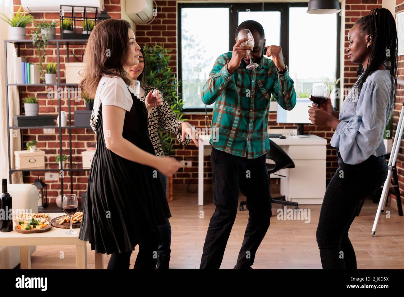 Cheerful people in living room at home enjoying wine party while ...