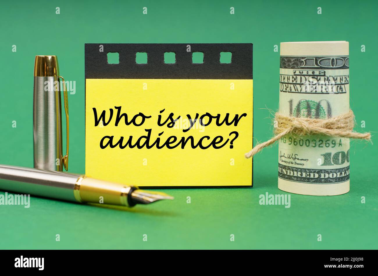 Business concept. On a green surface, a pen, dollars, a notepad and ...