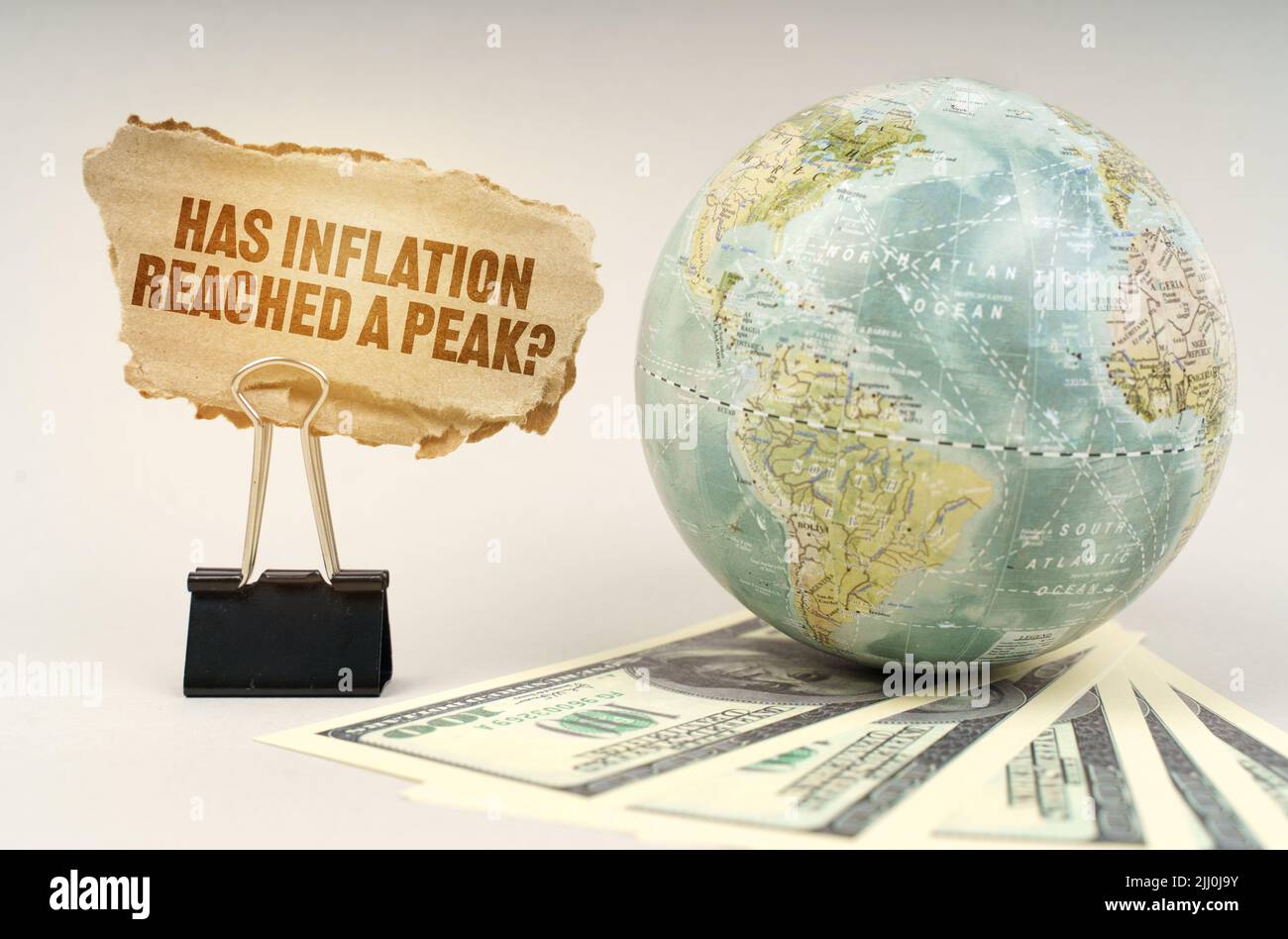 Business concept. On a gray surface, a globe, dollars and a cardboard ...