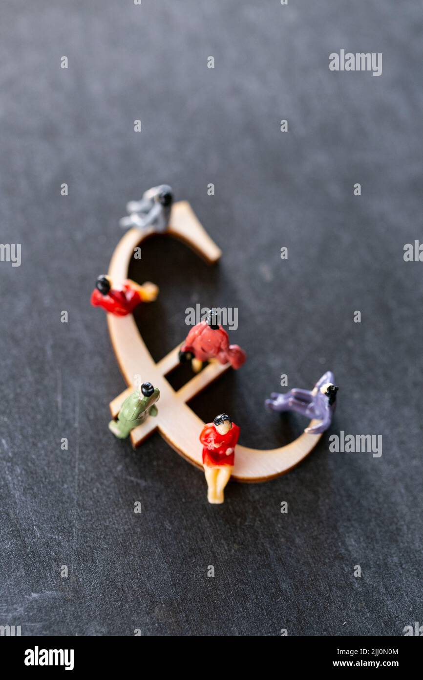 Euro sign and figurines of people on a black background.Taxpayers ...