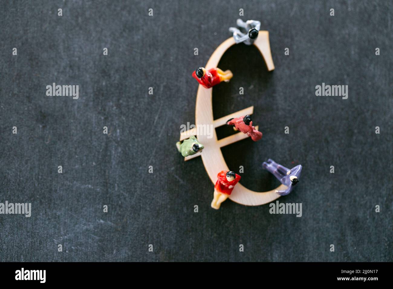 Euro sign and figurines of people on a black background.Euro inflation ...