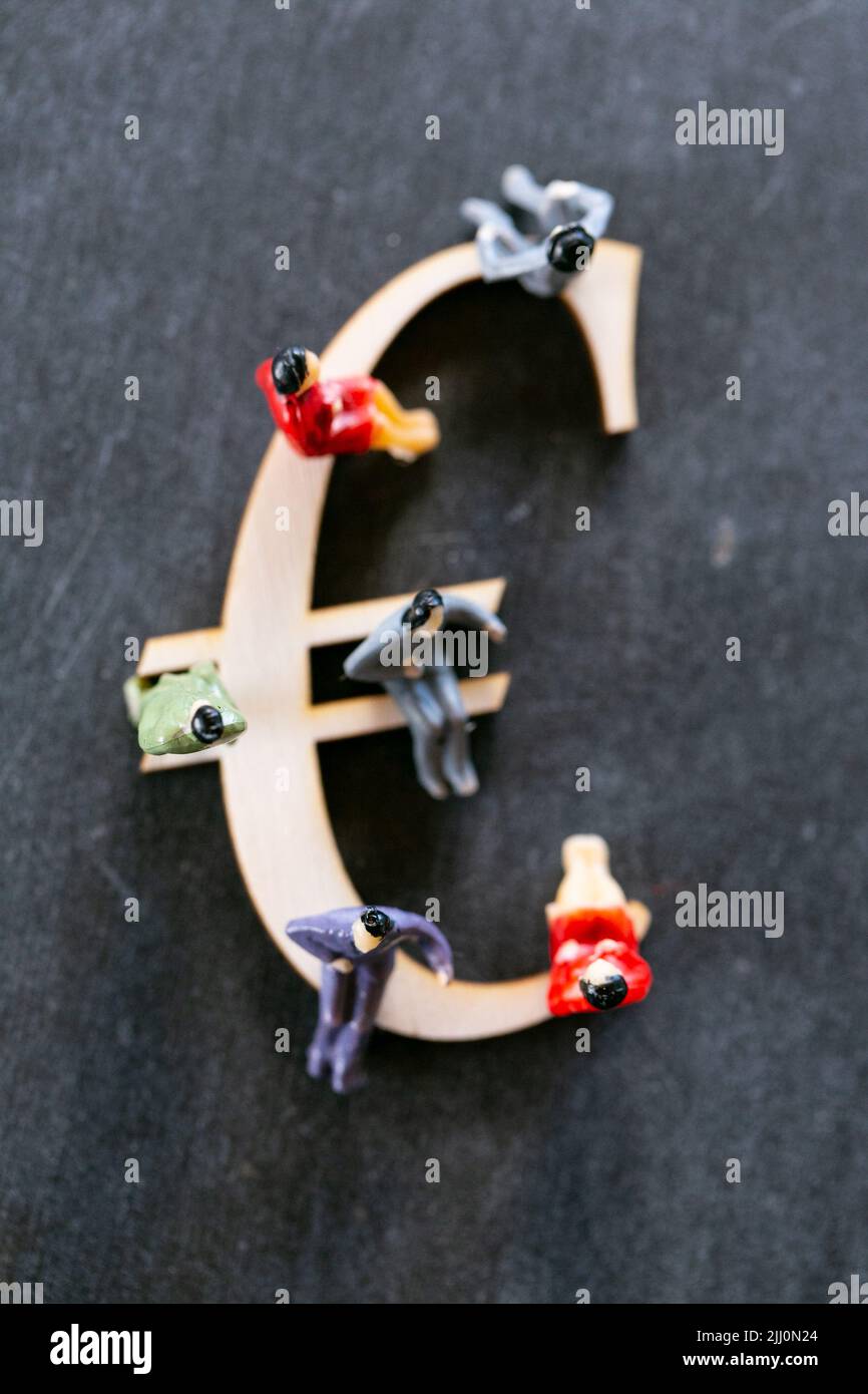 Euro inflation. Euro sign and figurines of people on a black background ...