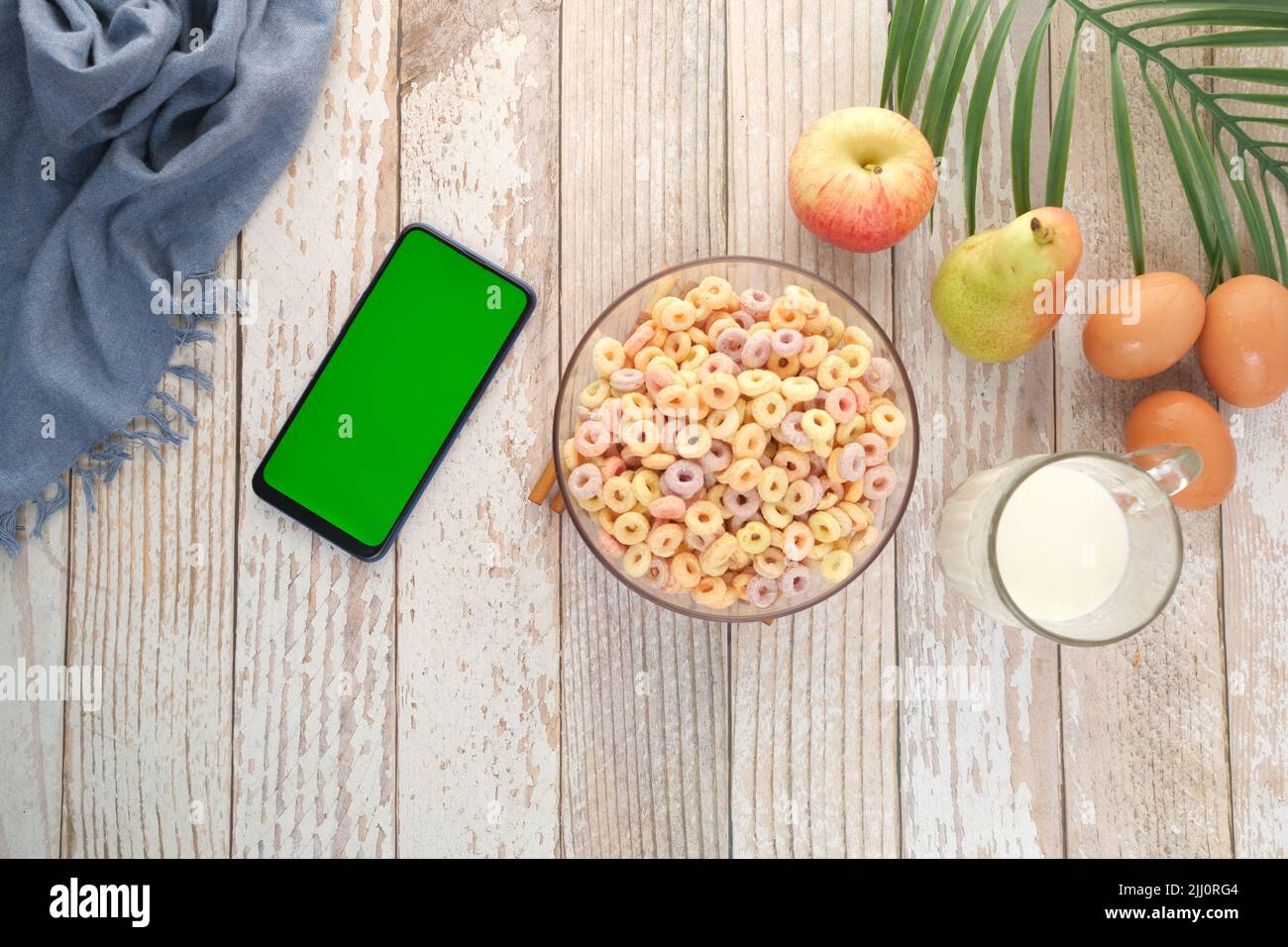 top view of colorful cereal corn flakes in a bowl and smart phone on ...