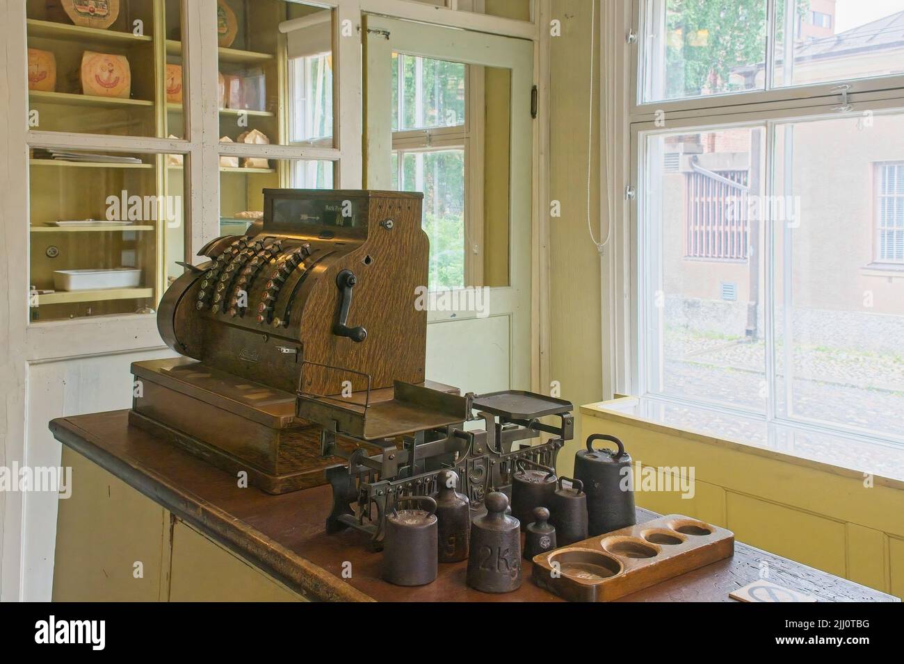 Cash register and iron weights on the counter of a shop at Amuri Museum ...