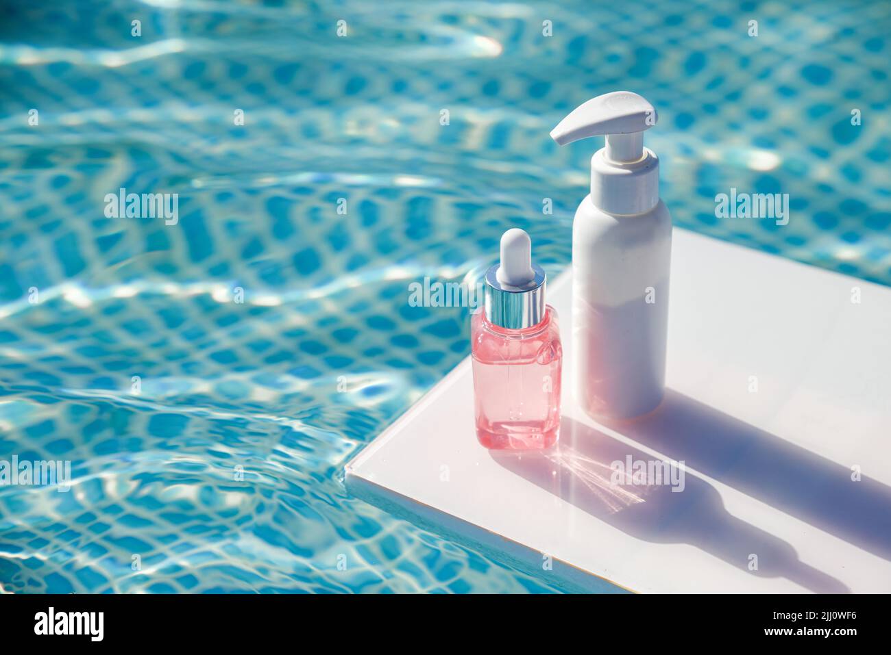 Bottle with serum, sunscreen lotion, sunblock cream on backdrop of ...
