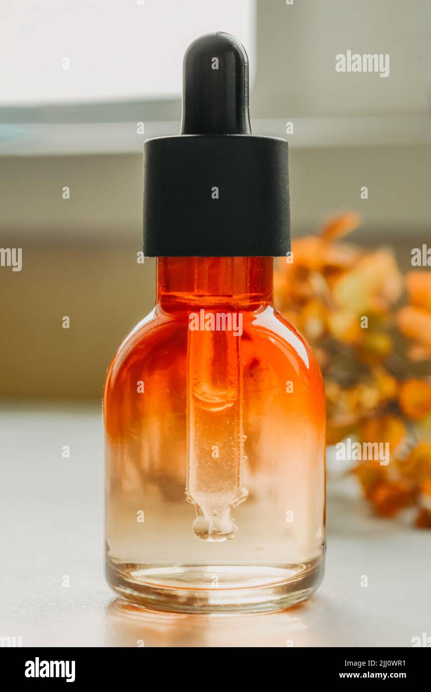 Serum with hyaluronic acid in orange bottle with pipette close-up. Spa ...