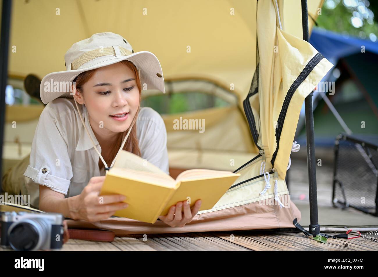 Attractive and beautiful young Asian female relaxes reading a book and ...