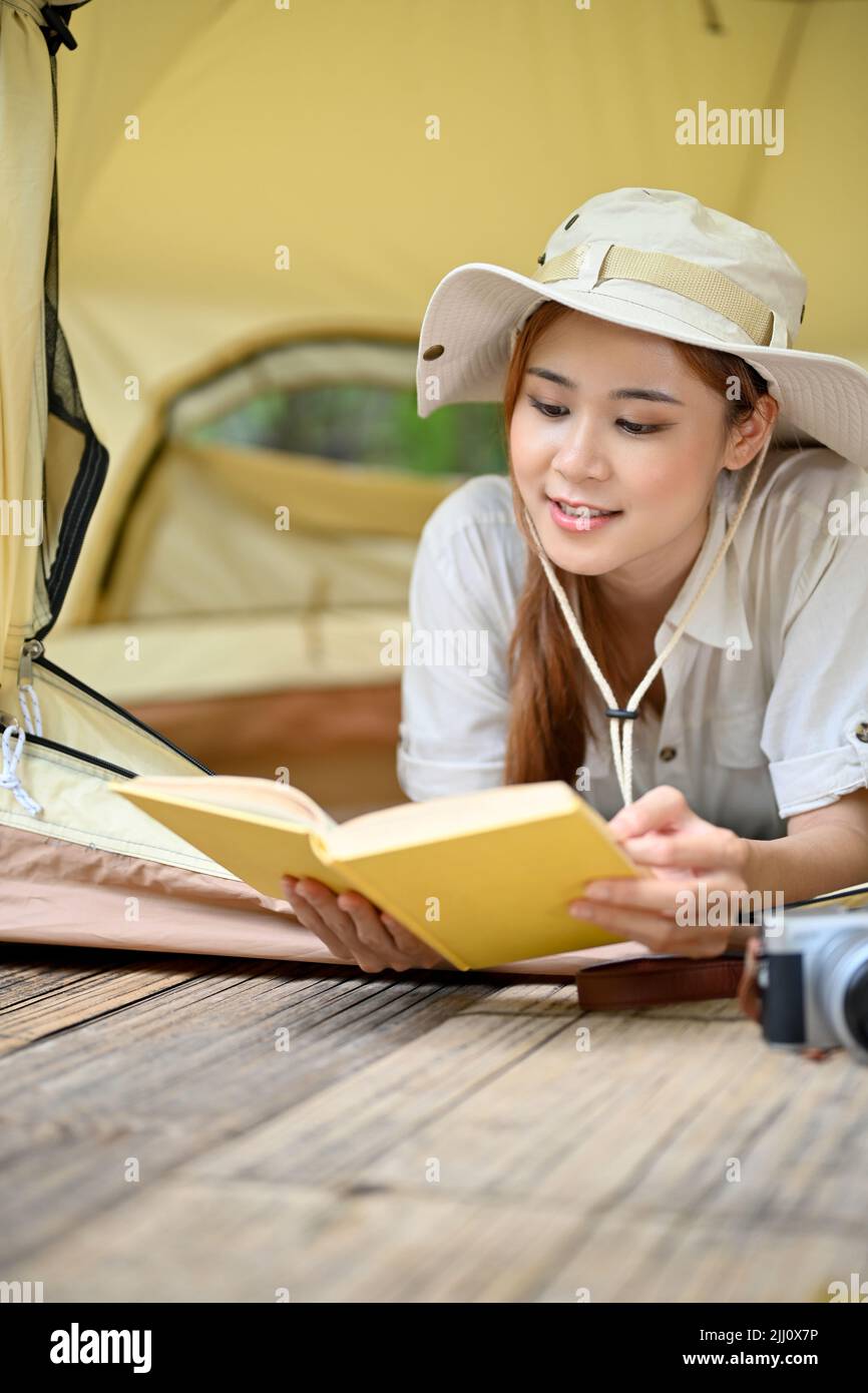 Portrait, Beautiful young Asian female relaxes reading a book while ...
