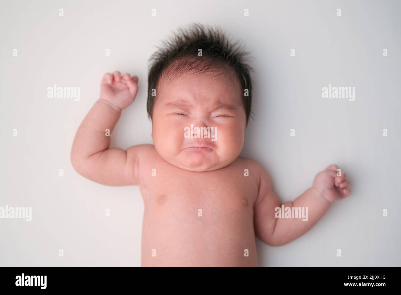 A newborn baby hungry on the bed and crying. Healthy little kid shortly ...