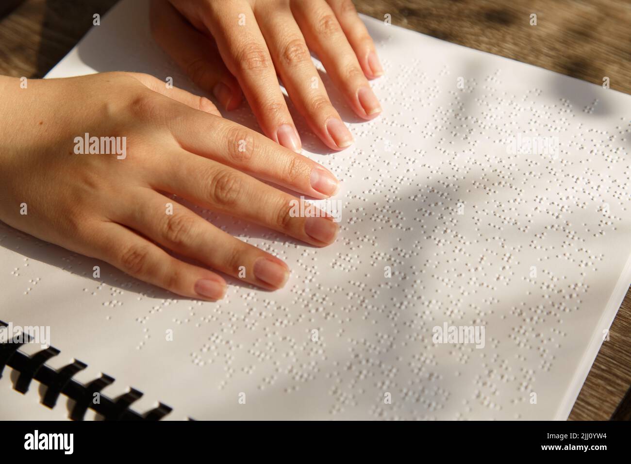 Women's hands lie on a page with braille Stock Photo - Alamy