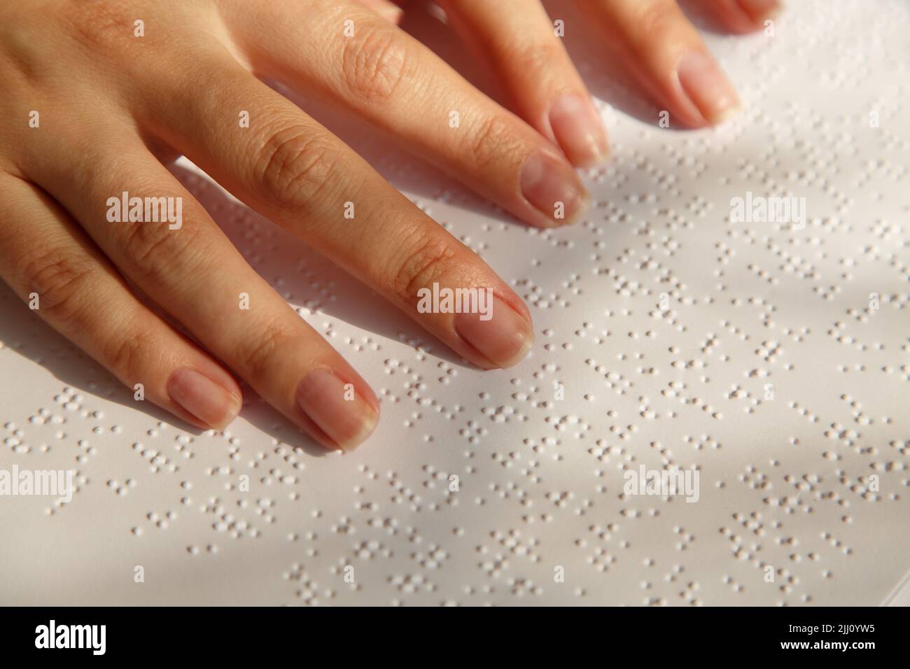 Woman's fingers on a book page with braille Stock Photo - Alamy