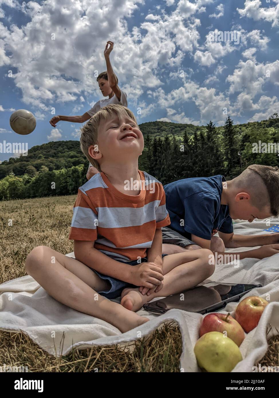 Children - playing ball and phone outside Stock Photo - Alamy