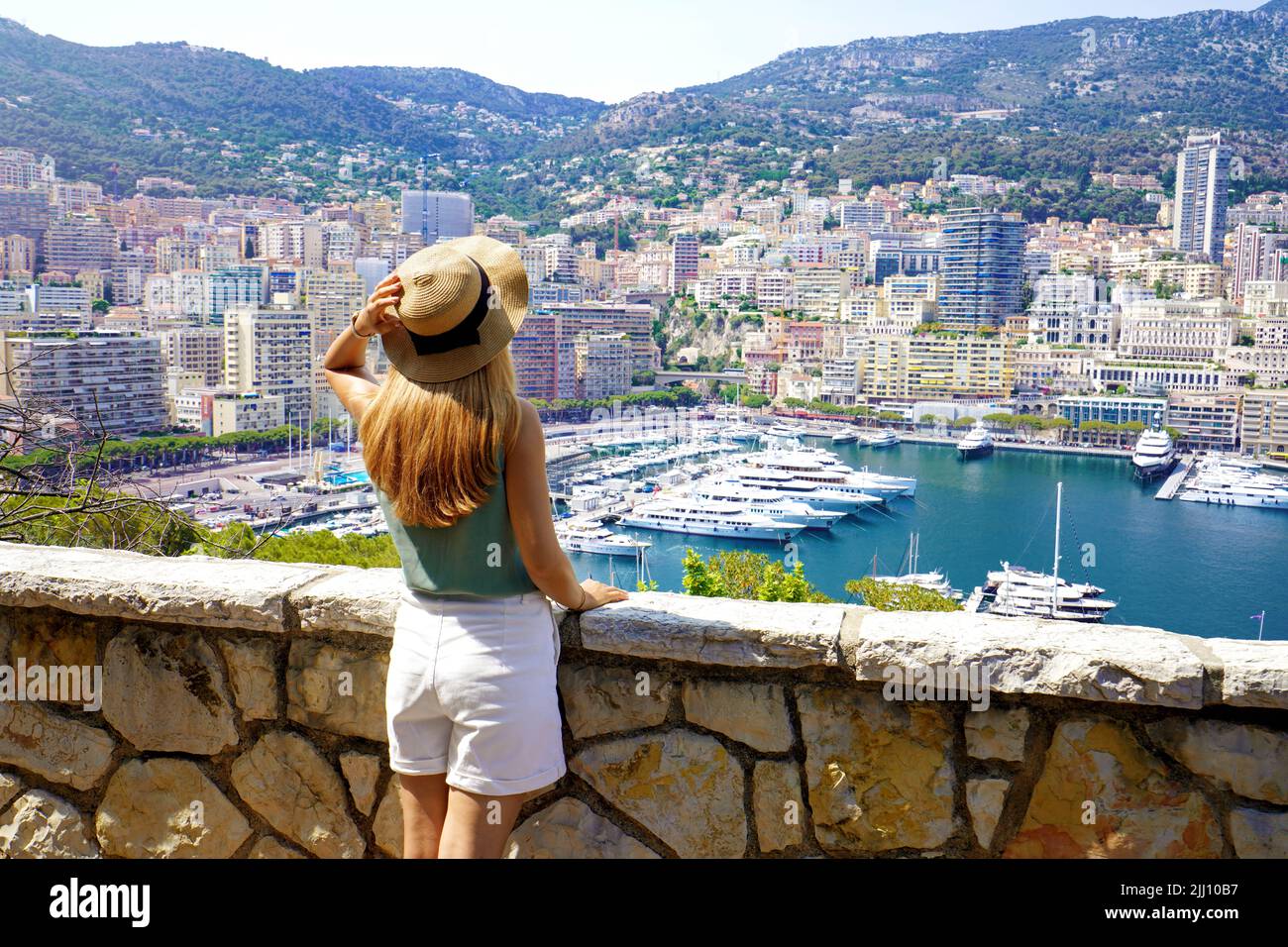 Beautiful fashion woman looking Monte Carlo cityscape with skyscrapers and harbor in the ...