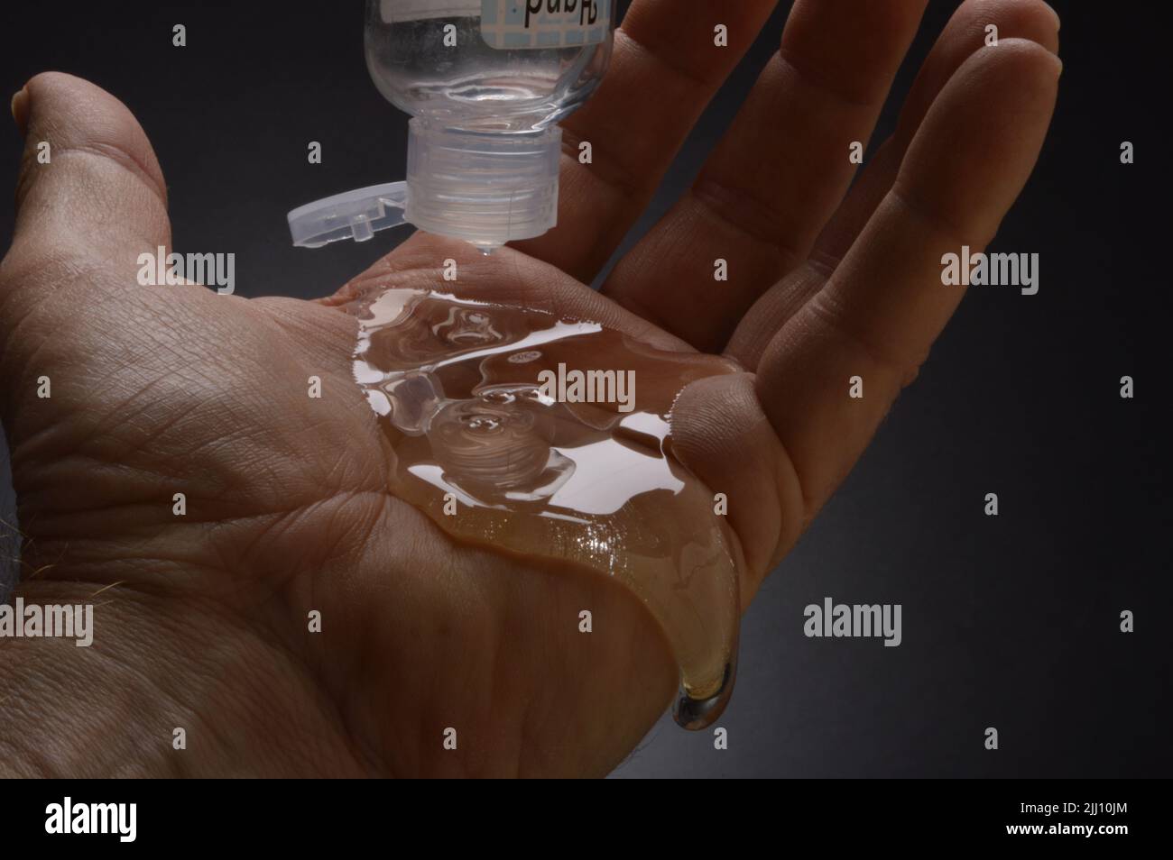Hand sanitizer dripping into and overflowing from hand Stock Photo - Alamy