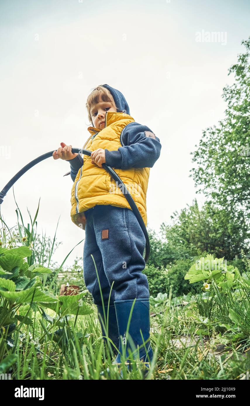 Cute boy watering plants in hi-res stock photography and images - Alamy